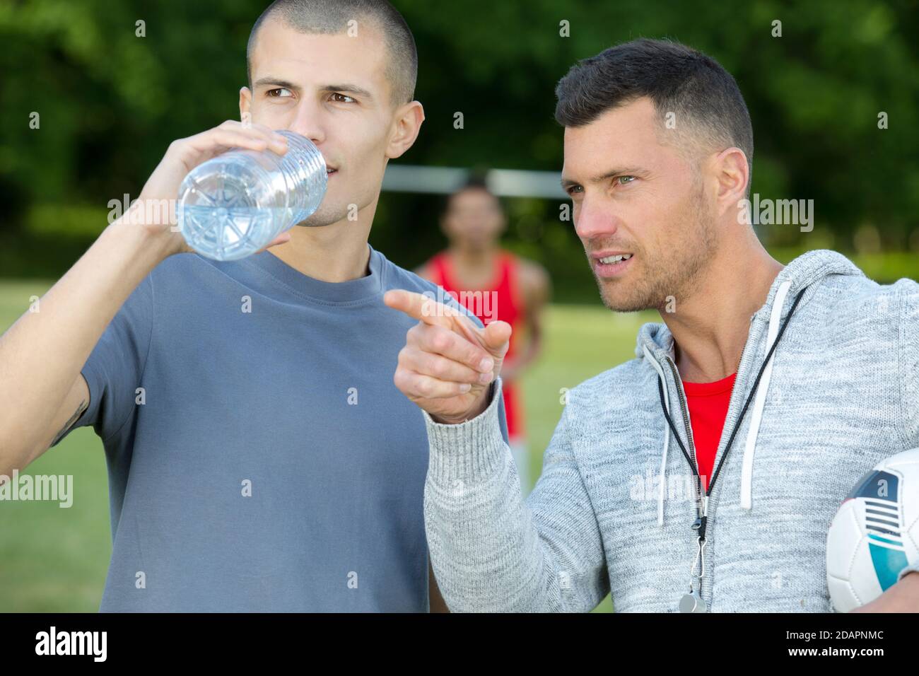 two men drinking water outdoors Stock Photo - Alamy