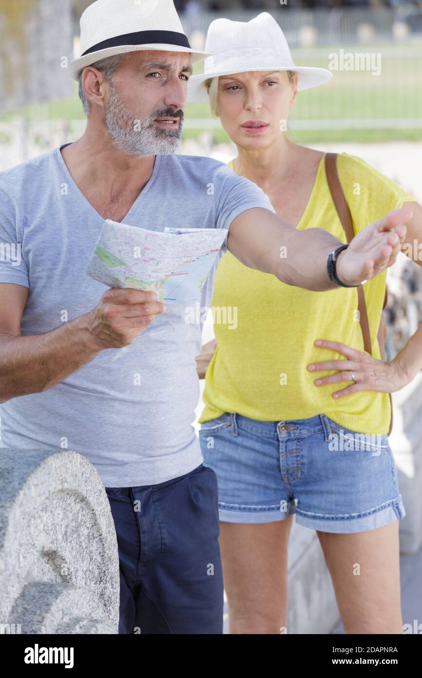 couple looking for directions using a map on holidays Stock Photo - Alamy