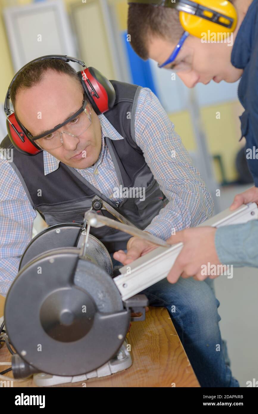 young manual worker grinding metal in industry Stock Photo - Alamy