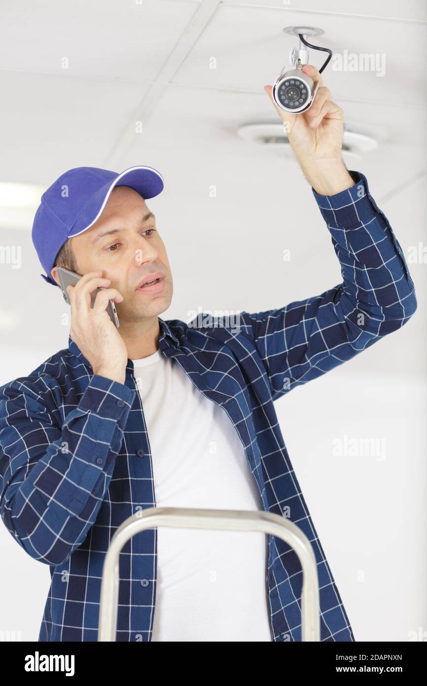man on the phone and cctv security camera Stock Photo - Alamy