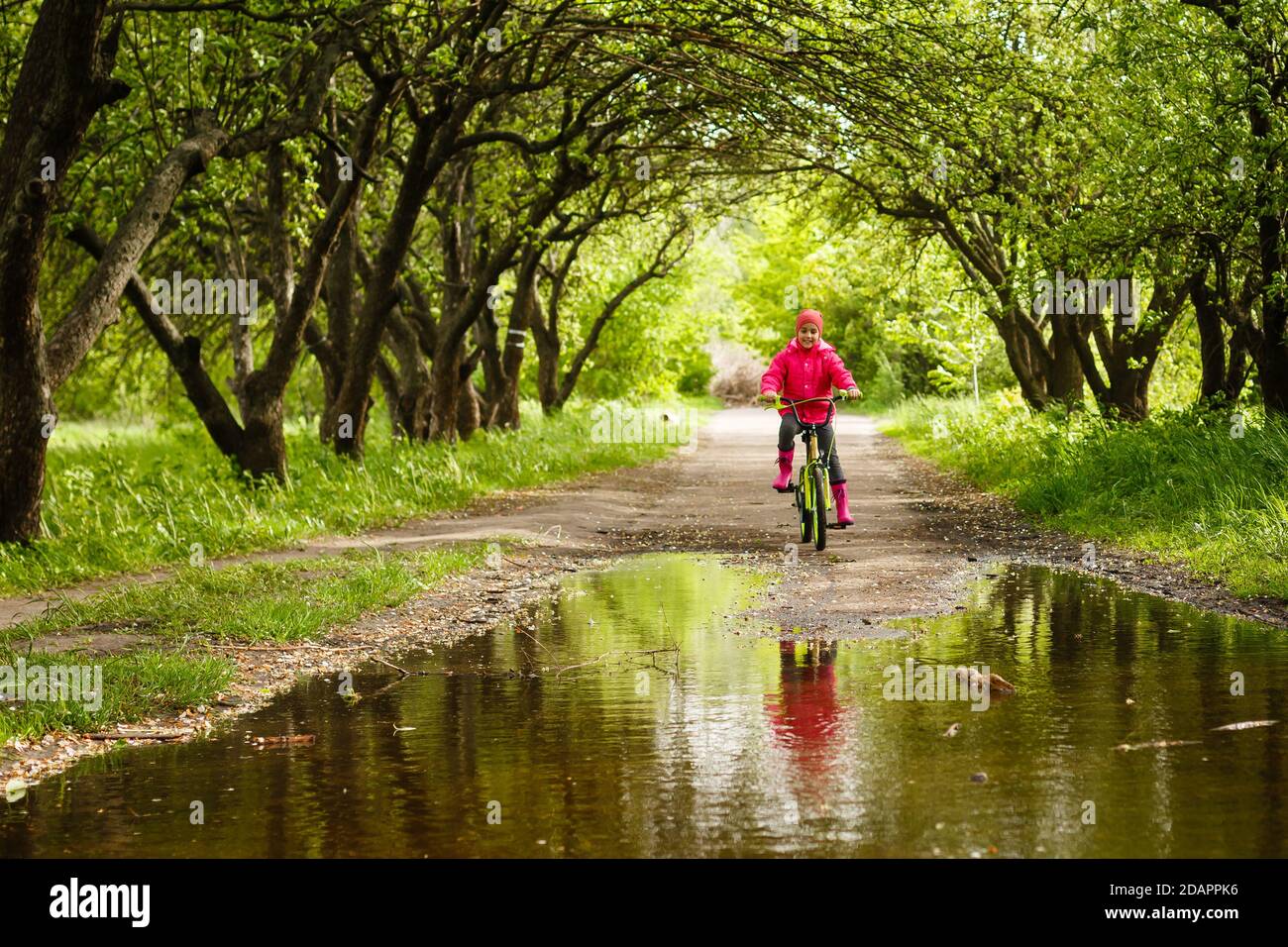 little girl riding bike in water puddle Stock Photo - Alamy