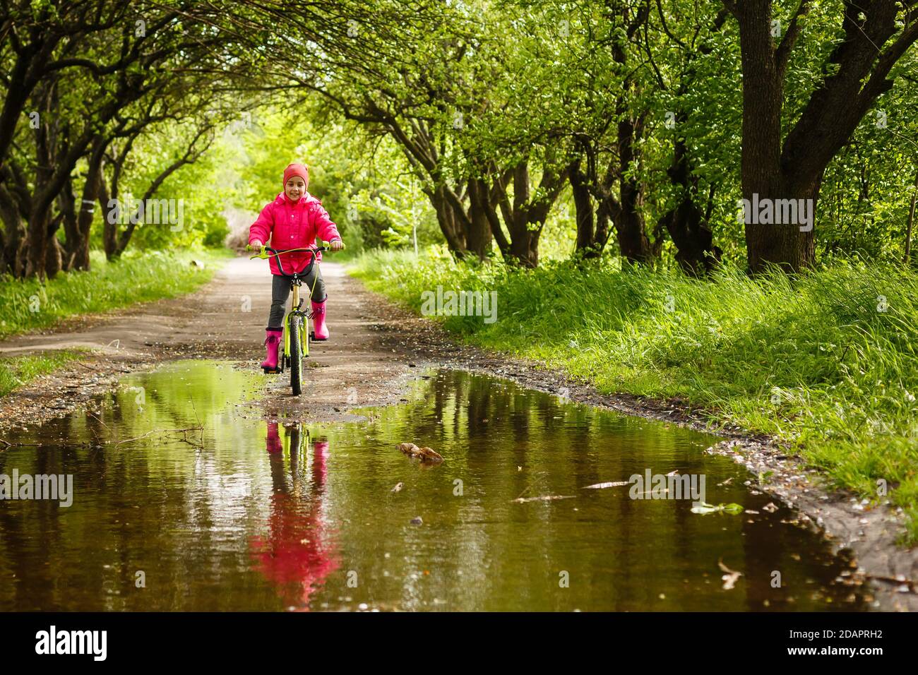little girl riding bike in water puddle Stock Photo - Alamy