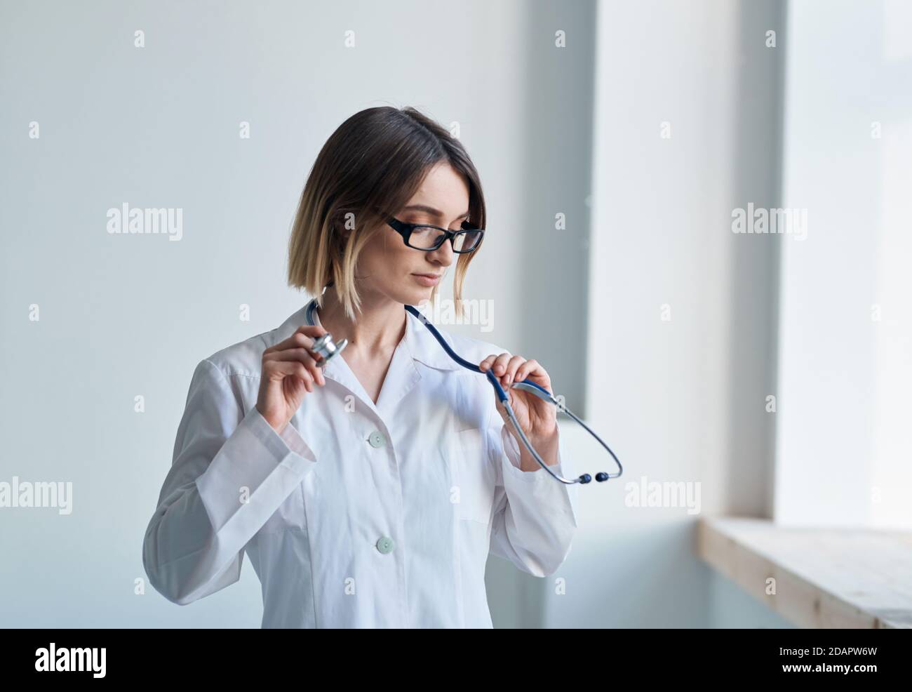 Brunette female doctor stands hi-res stock photography and images - Alamy