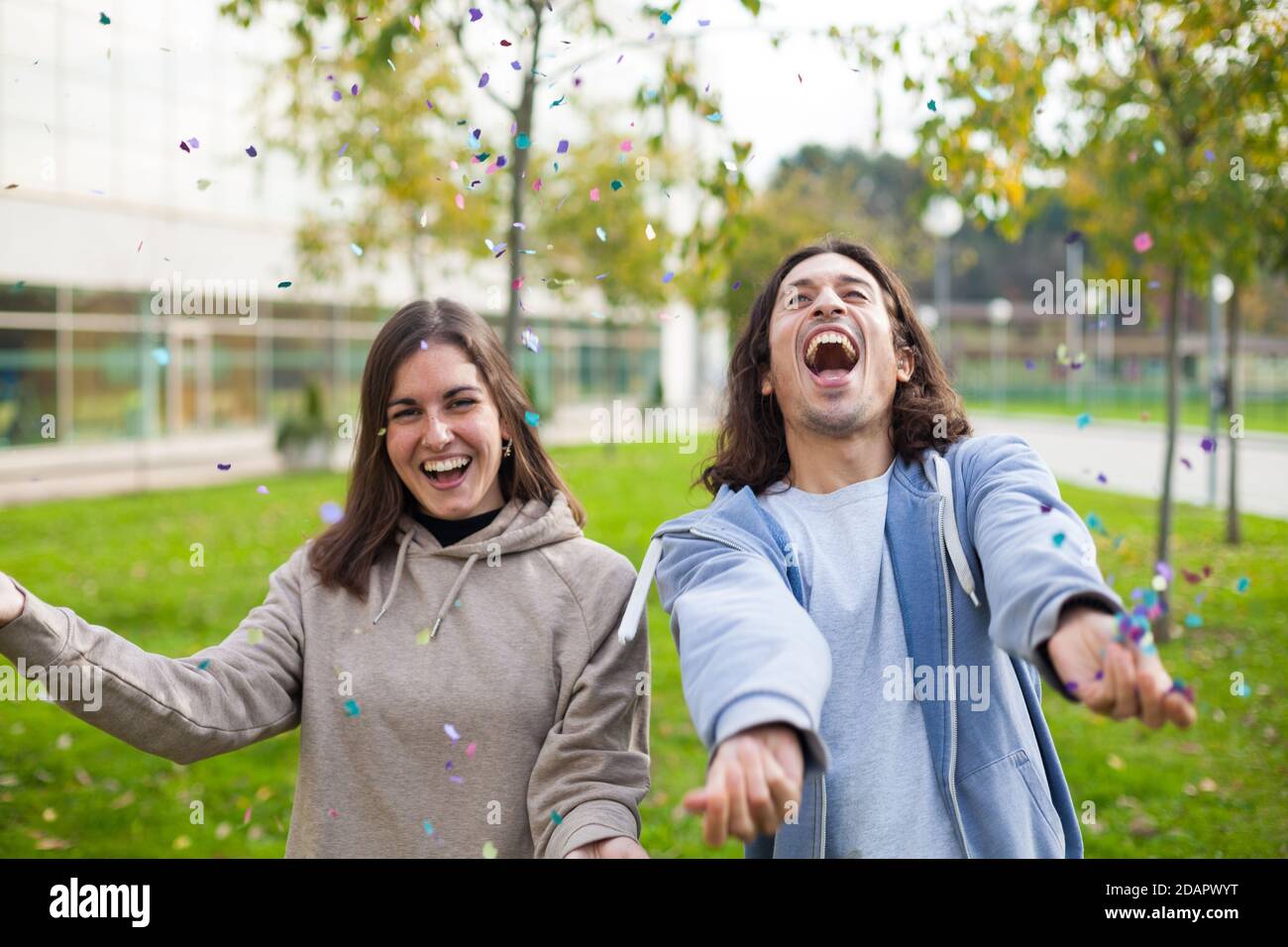 two friends having fun celebrating with confetti outdoor Stock Photo ...