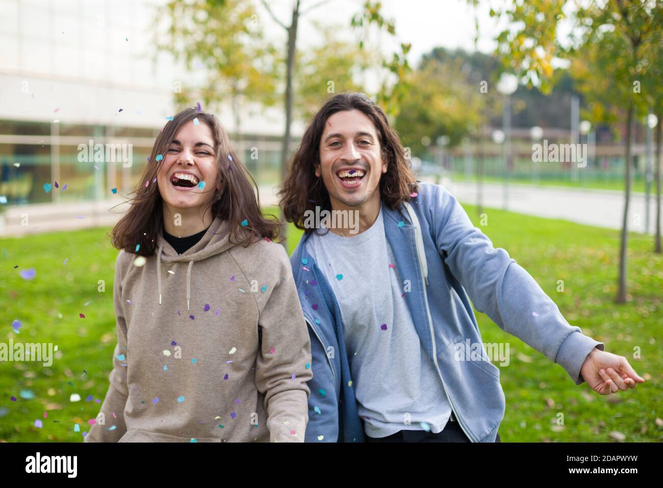 two friends having fun celebrating with confetti outdoor Stock Photo ...