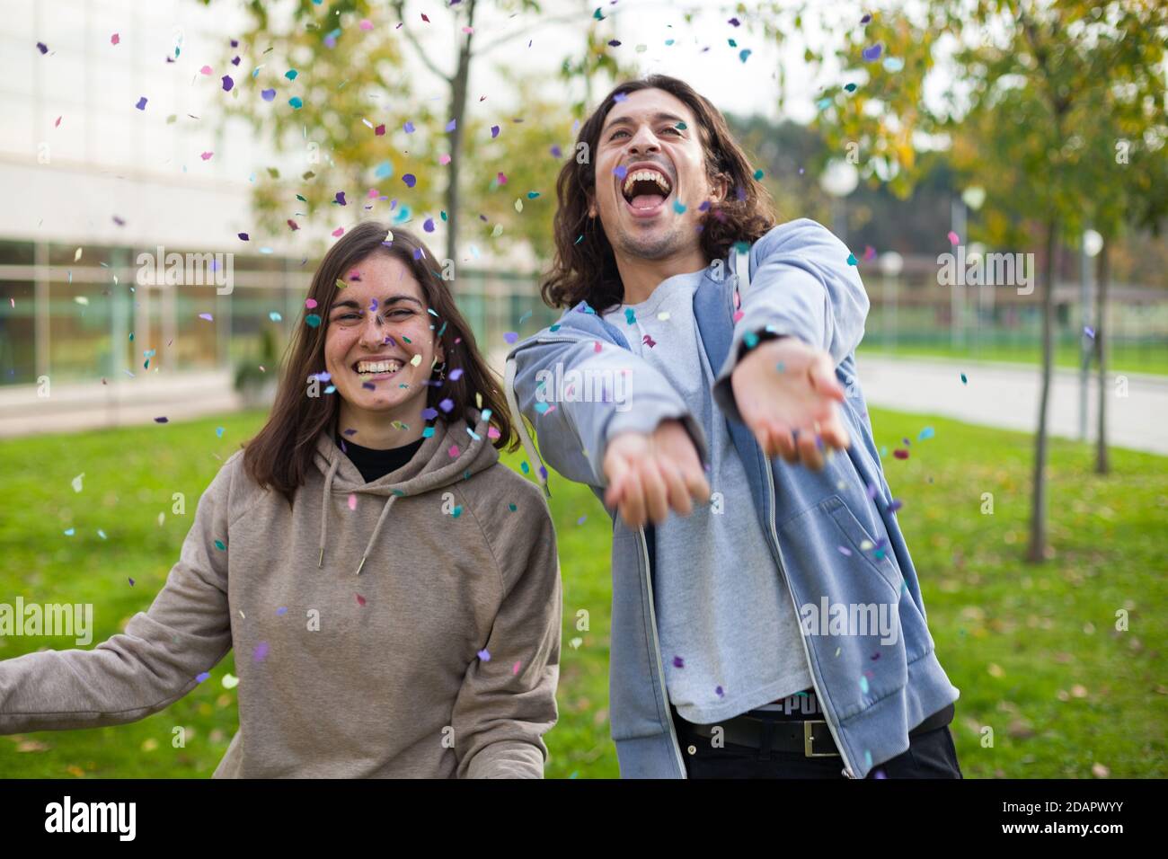 two friends having fun celebrating with confetti outdoor Stock Photo ...