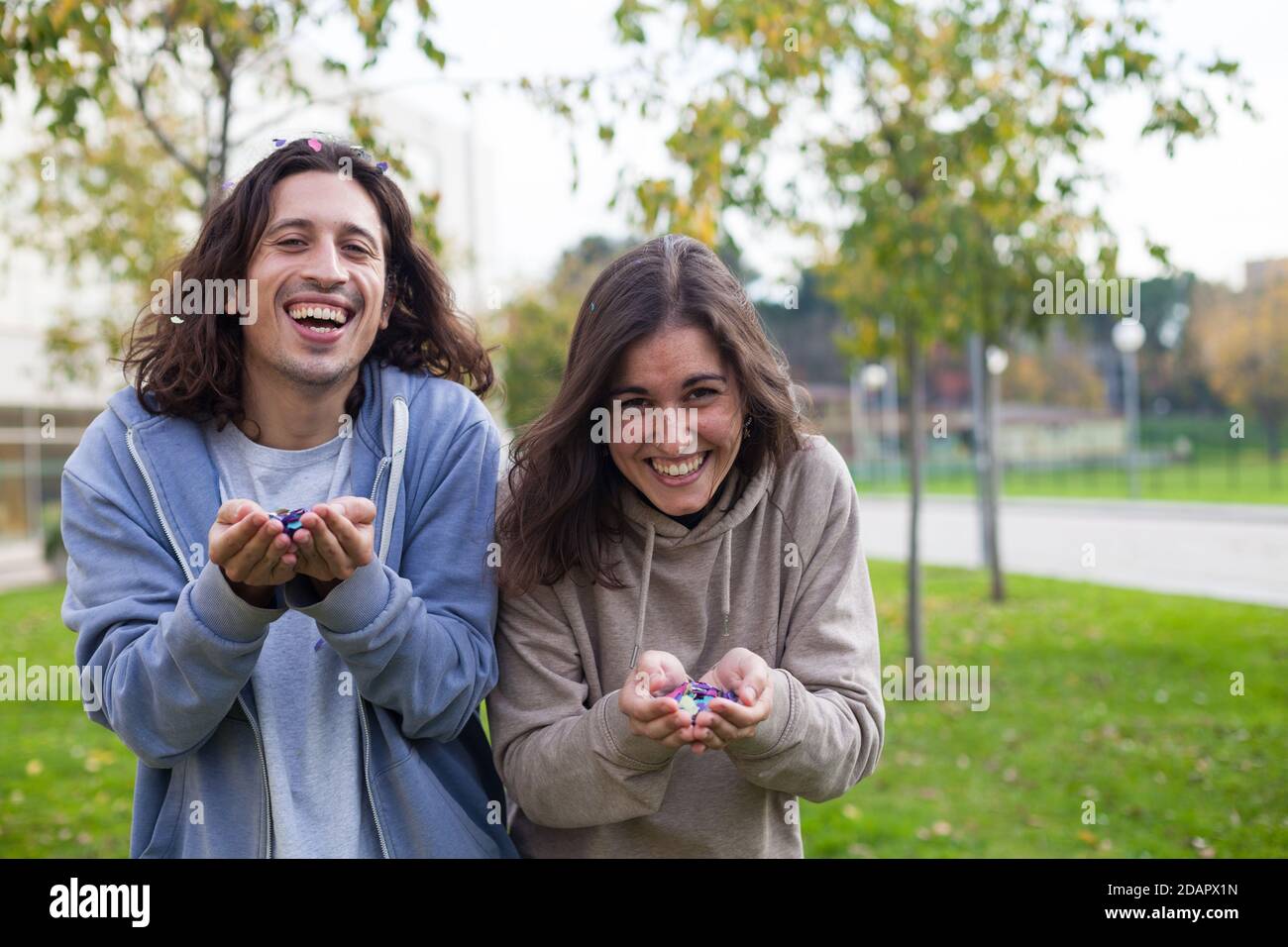 two friends having fun celebrating with confetti outdoor Stock Photo ...