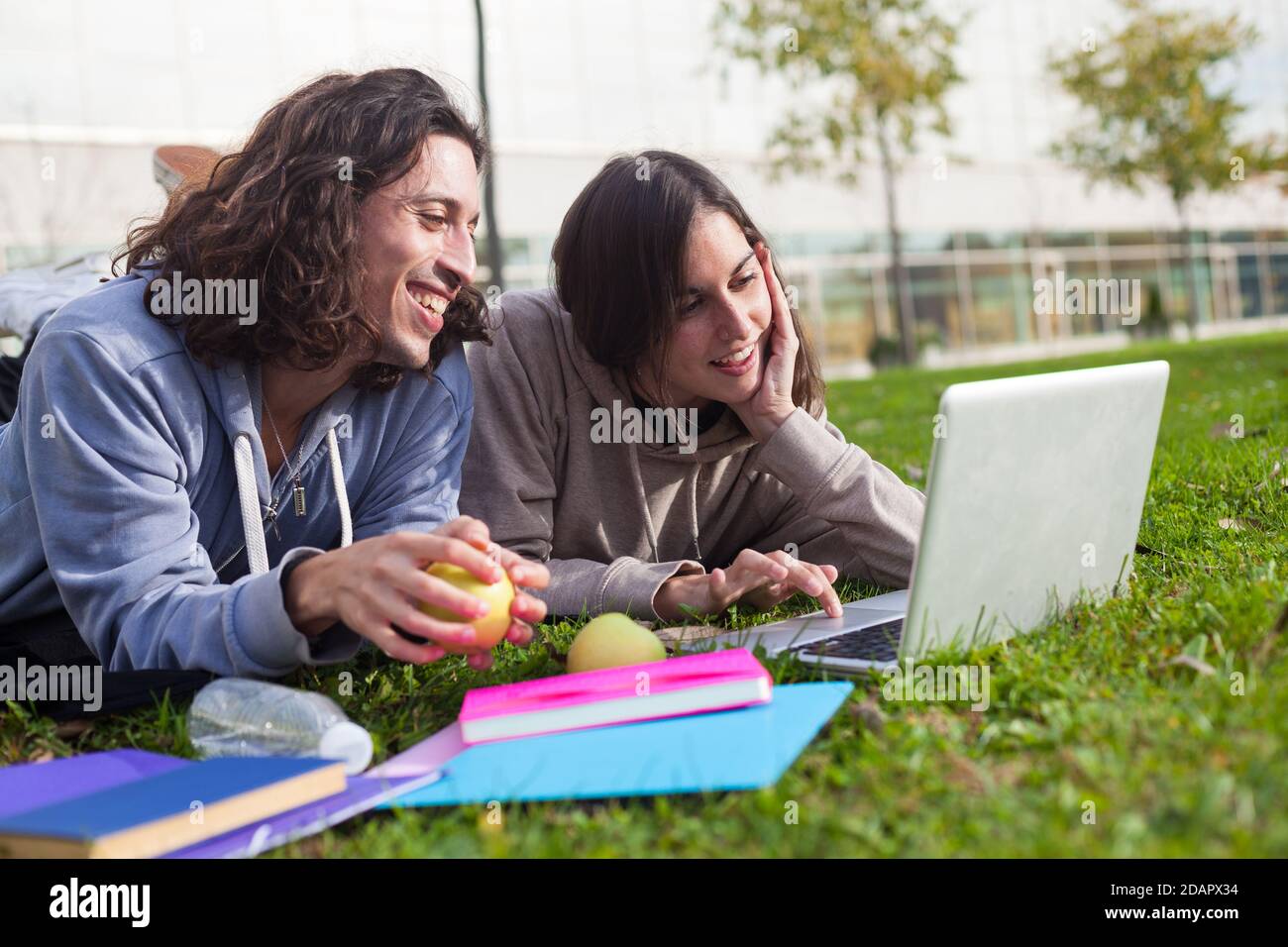 two happy university students studying outdoor at the school campus ...