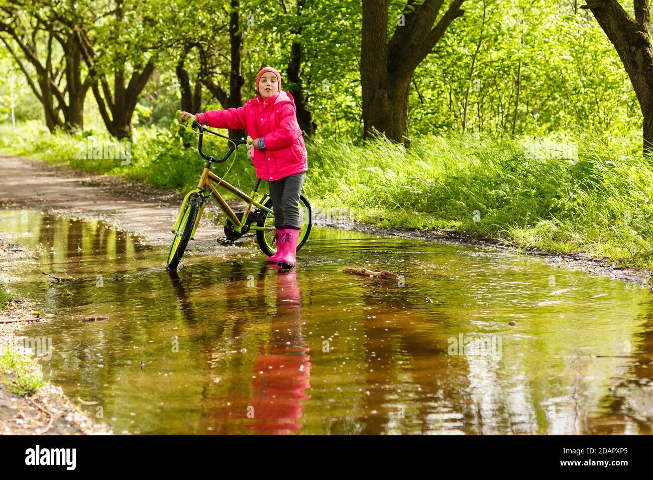 little girl riding bike in water puddle Stock Photo - Alamy