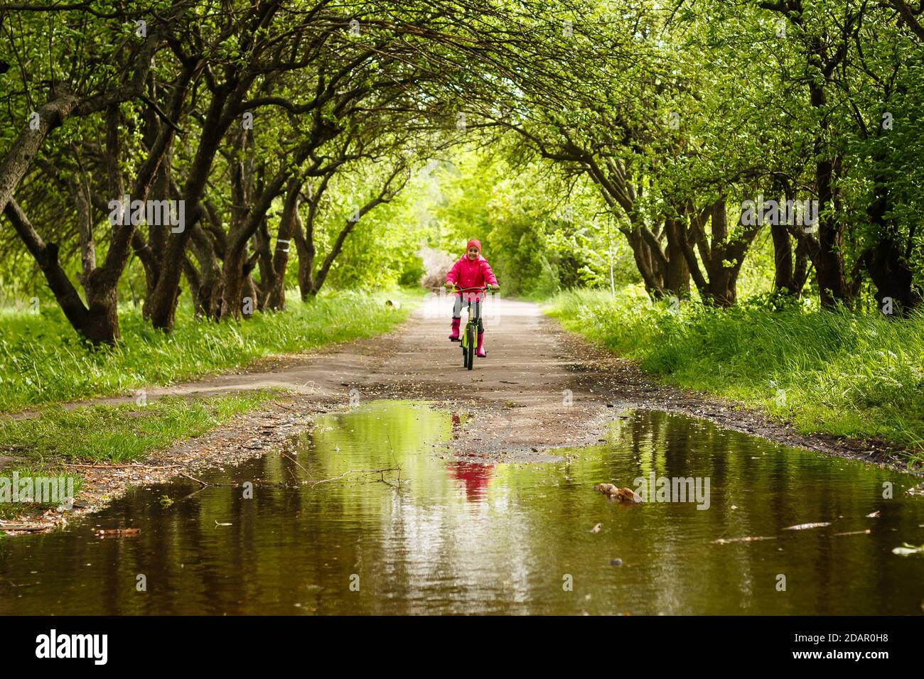little girl riding bike in water puddle Stock Photo - Alamy