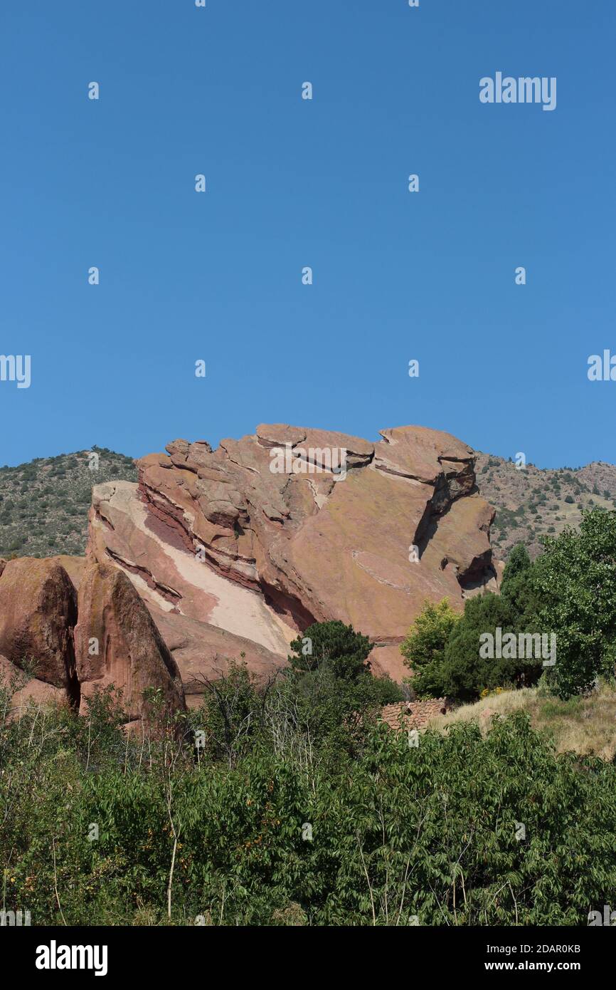 Red sandstone rock formations surrounded by shrubs and trees with ...