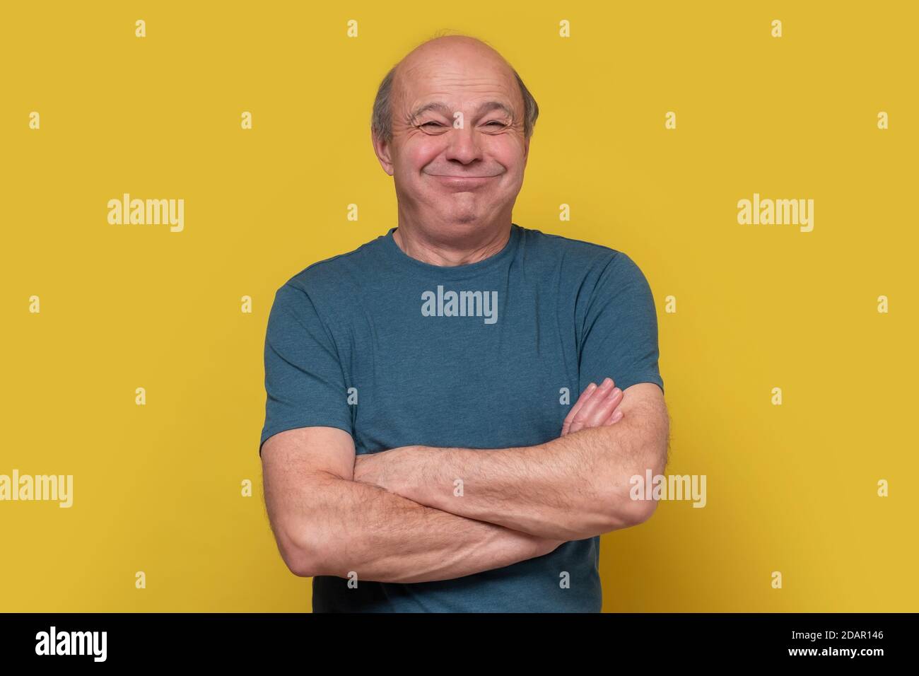Elderly caucasian man barely holding back laughter, puffing out his ...