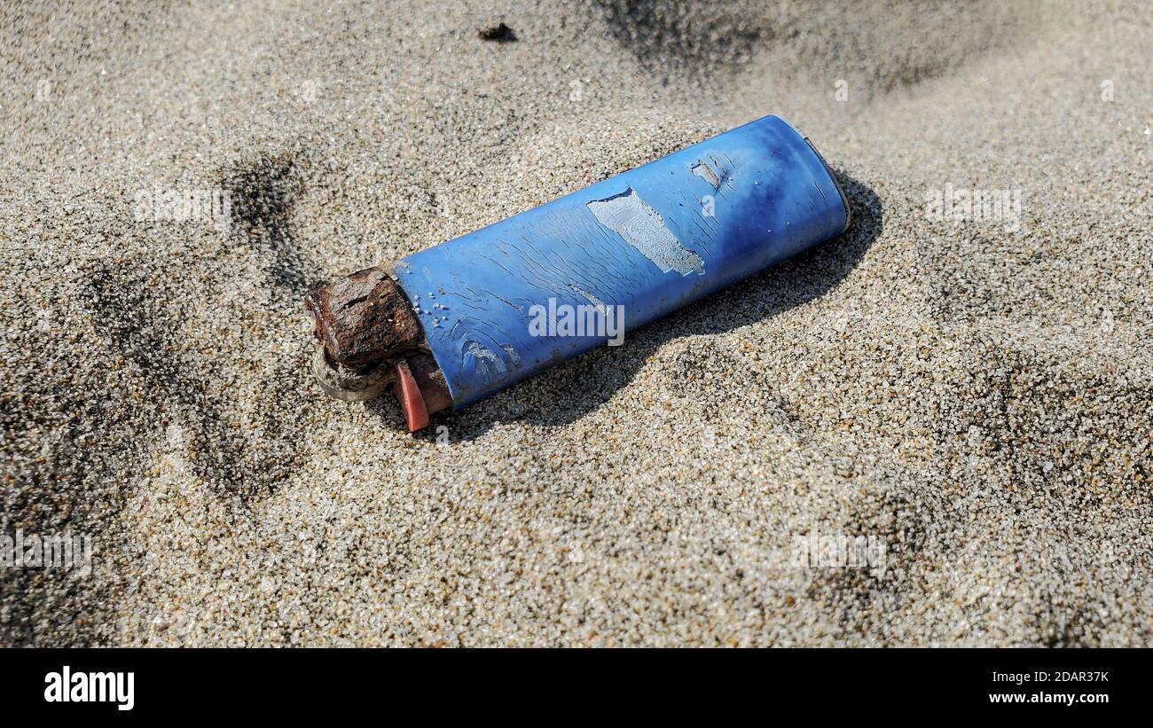 Salt rust Corroded Plastic lighter discarded on sandy sea ecosystem ...