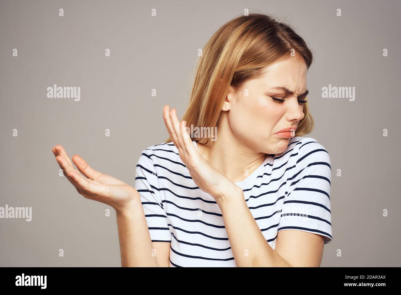 A woman with a displeased expression is gesturing with her hands T ...