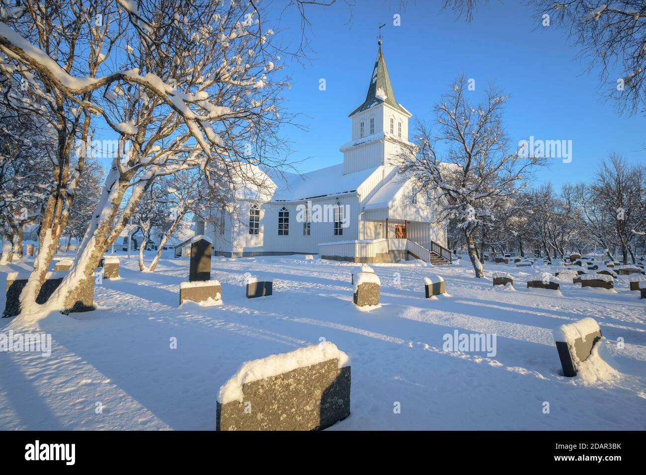 Fore wooden church with snowy cemetery with gravestones, Reipa ...