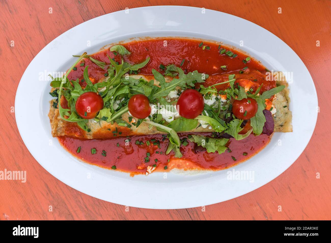 Stuffed pancakes with rocket and tomato sauce, Germany Stock Photo - Alamy