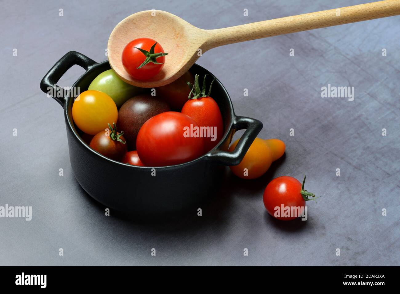 Different cherry tomatoes in pot with cooking spoon, Germany Stock ...