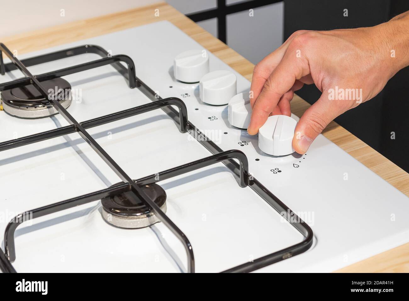 a man's hand turns on the gas stove Stock Photo - Alamy