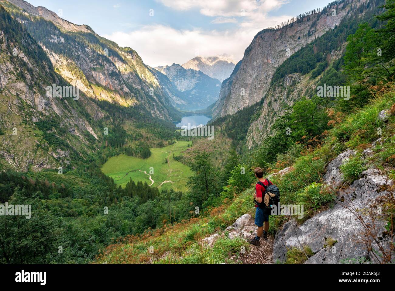 Hiker on the Roethsteig, view of the Obersee and Koenigssee, behind ...