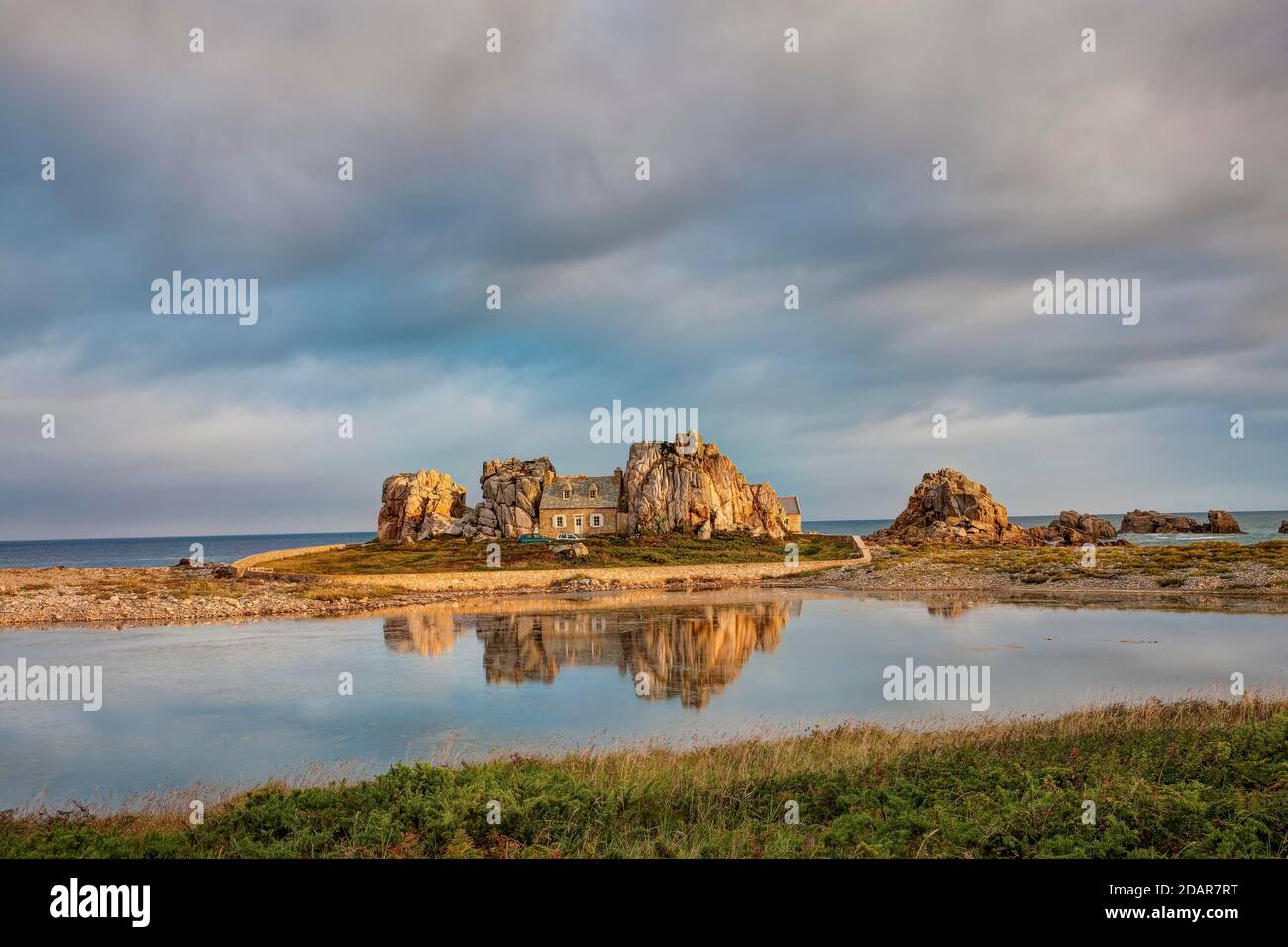 House between granite rocks with water reflection, Plougrescant ...