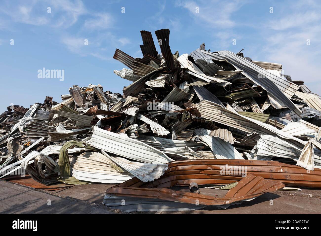 Metal scrap, bent corrugated sheet metal from an industrial hall ...