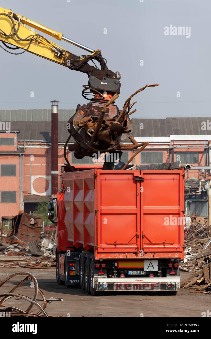 Excavator loads metal scrap onto truck, Demolition of an industrial ...