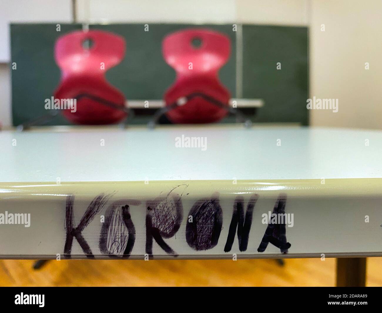 Empty classroom, seated, lettering KORONA on table, single tables ...