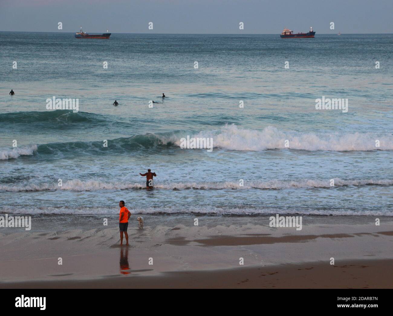 Surfing off the beach in Sardinero at dusk on a mild autumn evening ...