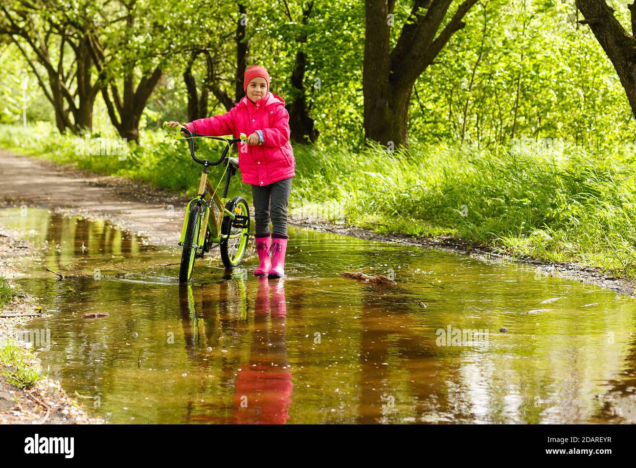 little girl riding bike in water puddle Stock Photo - Alamy