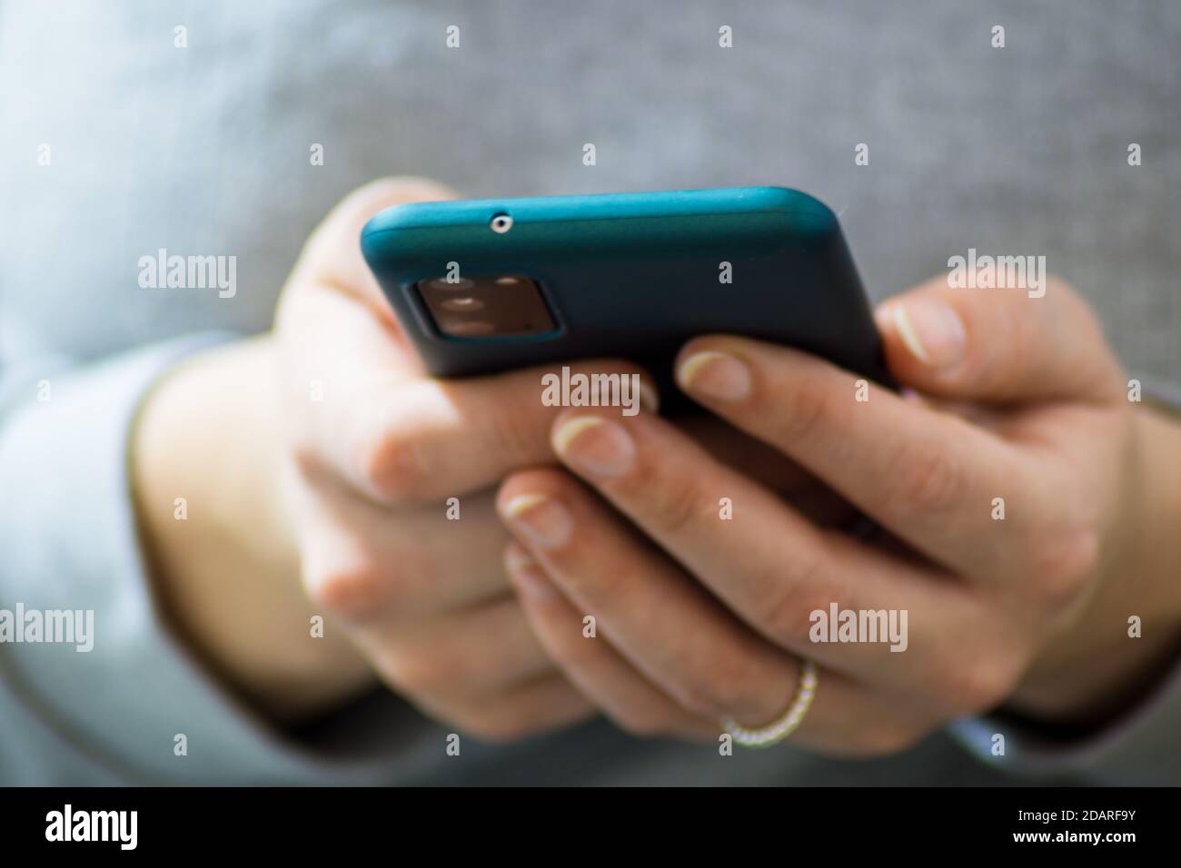 Frontal view of woman’s beautiful hands using the new smartphone with ...