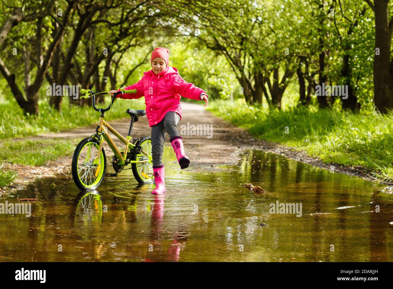 little girl riding bike in water puddle Stock Photo - Alamy