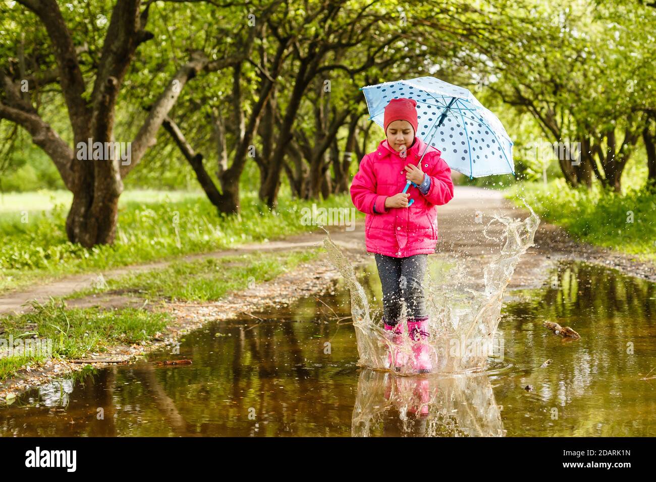 little girl riding bike in water puddle Stock Photo - Alamy