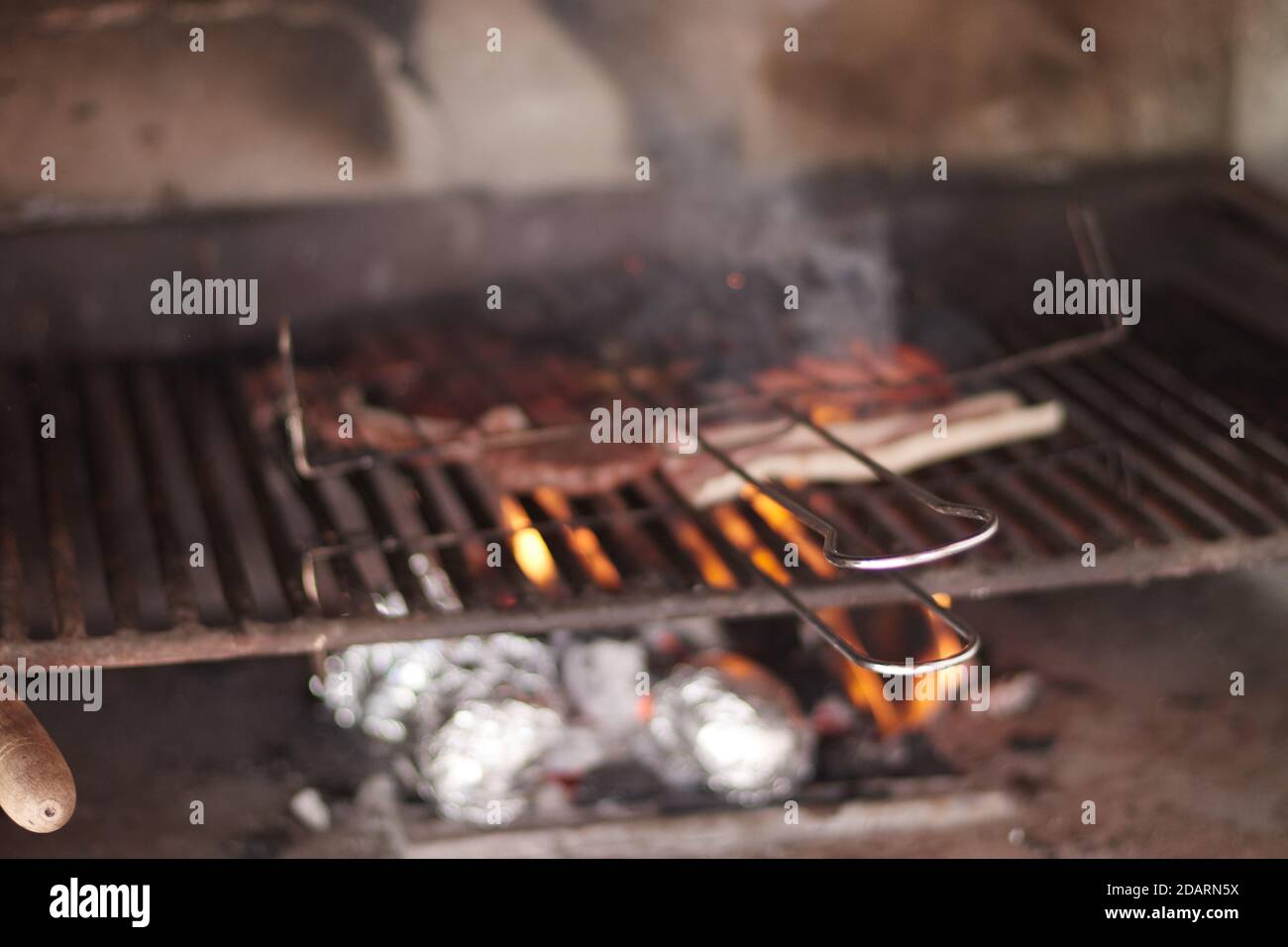 meat and vegetables cooking over fire on a grill Stock Photo - Alamy