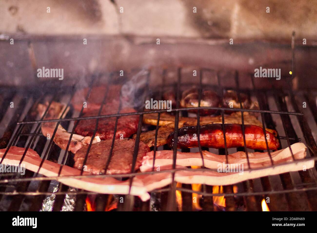 meat and vegetables cooking over fire on a grill Stock Photo - Alamy