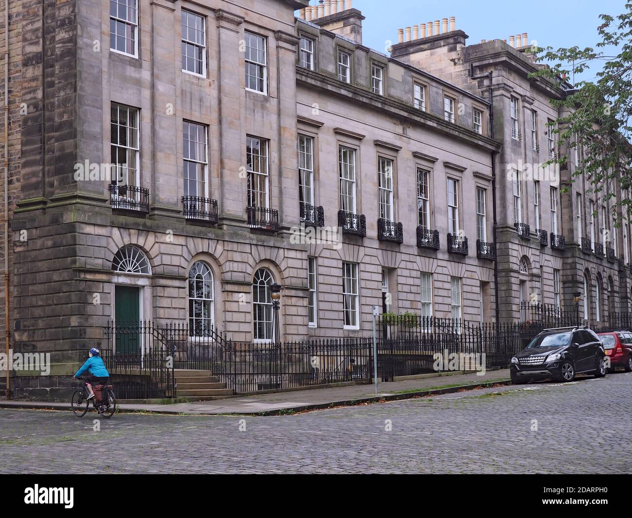 Old European apartment building or townhouse block on cobblestone paved ...