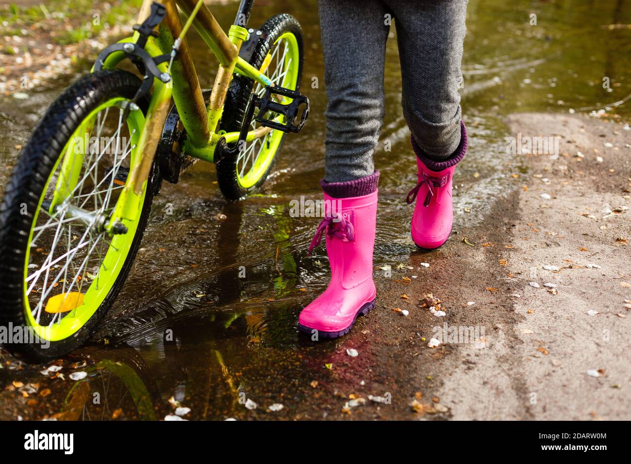 little girl riding bike in water puddle Stock Photo - Alamy