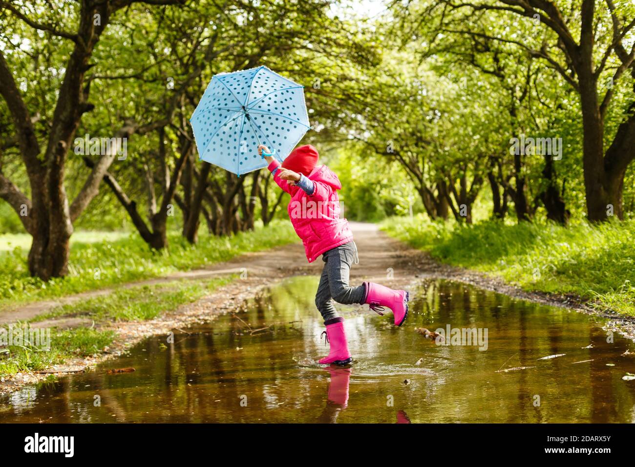 little girl riding bike in water puddle Stock Photo - Alamy