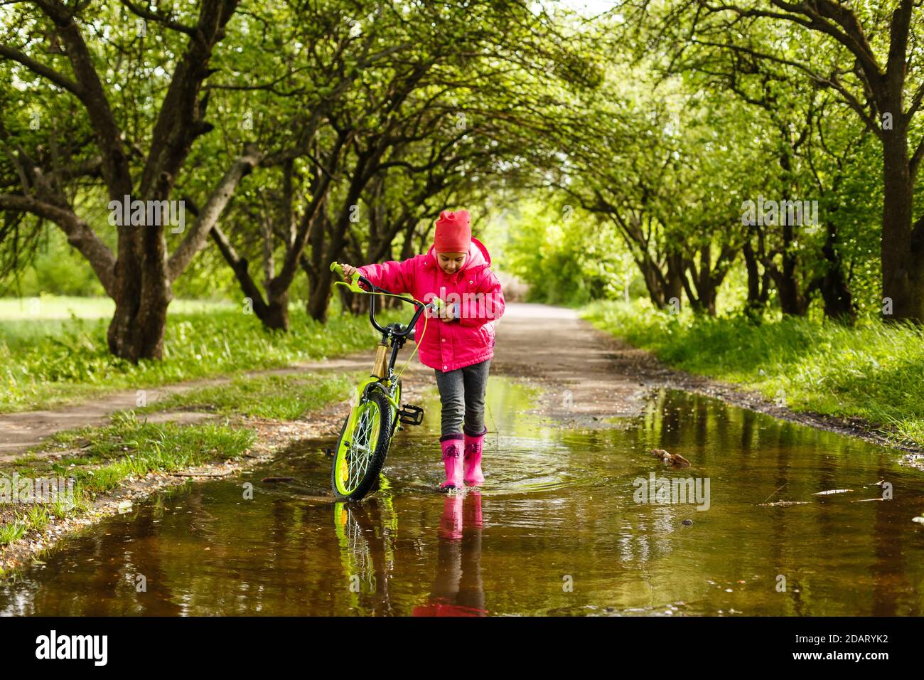 little girl riding bike in water puddle Stock Photo - Alamy