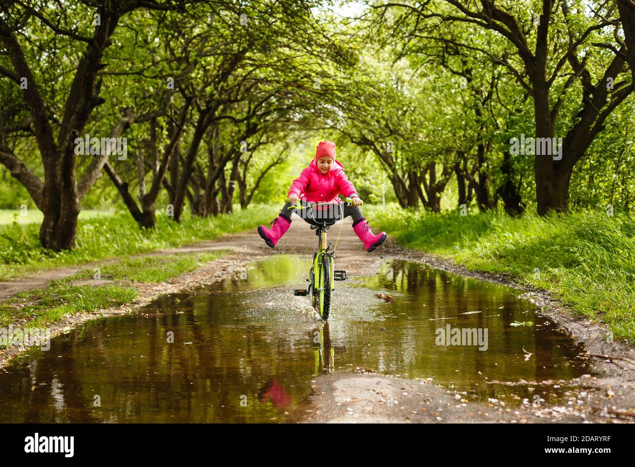 little girl riding bike in water puddle Stock Photo - Alamy