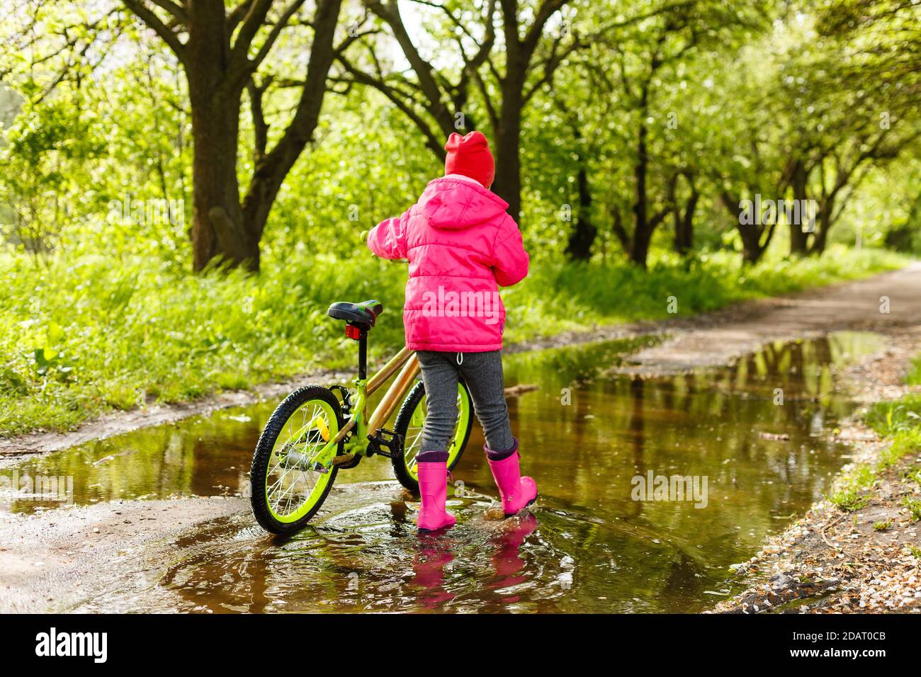little girl riding bike in water puddle Stock Photo - Alamy