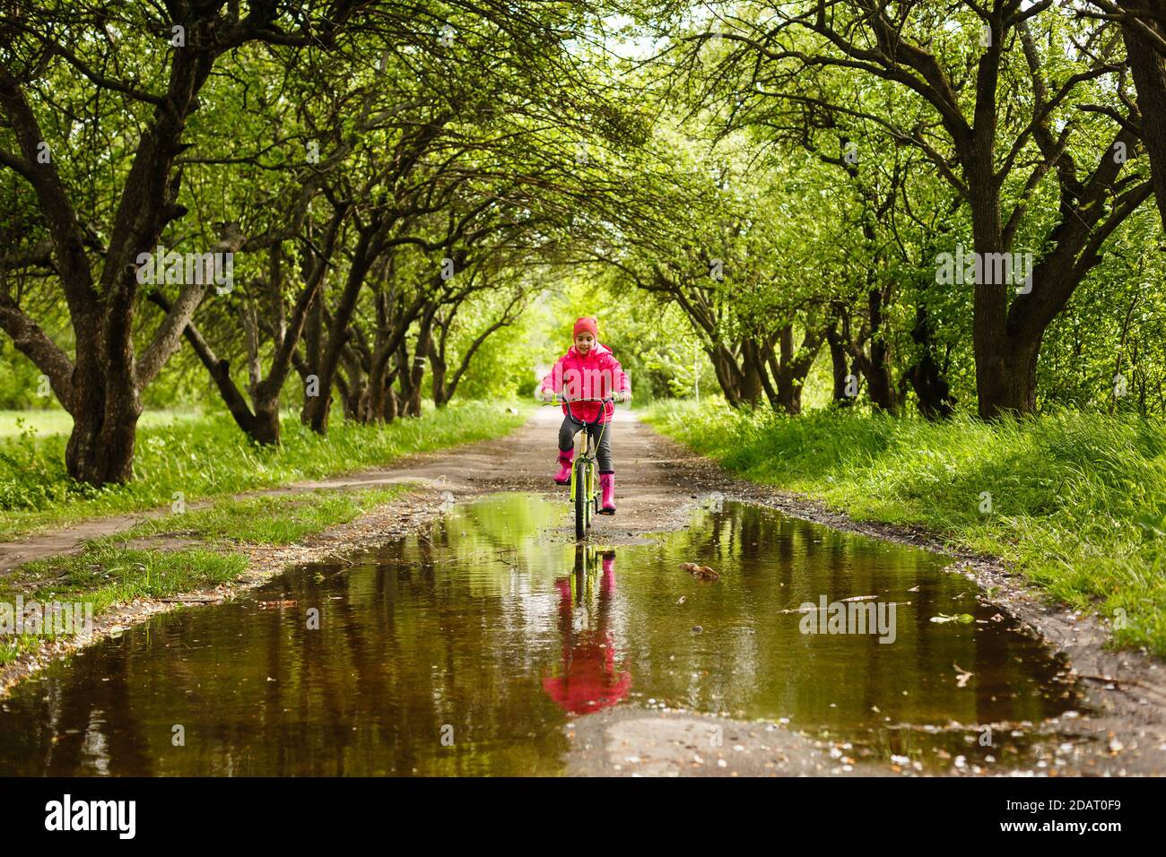 little girl riding bike in water puddle Stock Photo - Alamy