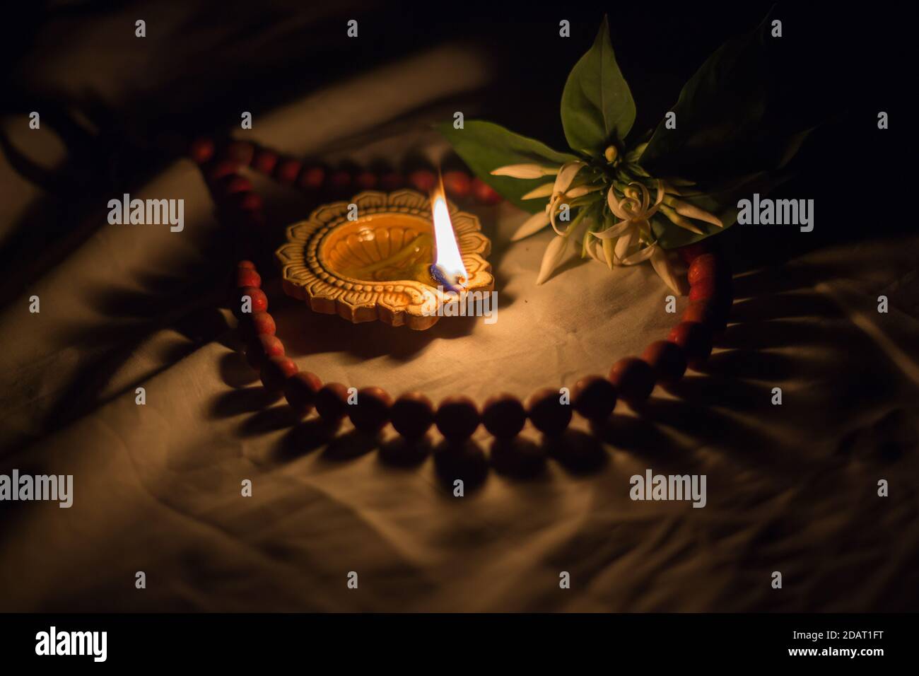 Indian traditional oil lamp made of clay with glowing flame, jasmine ...
