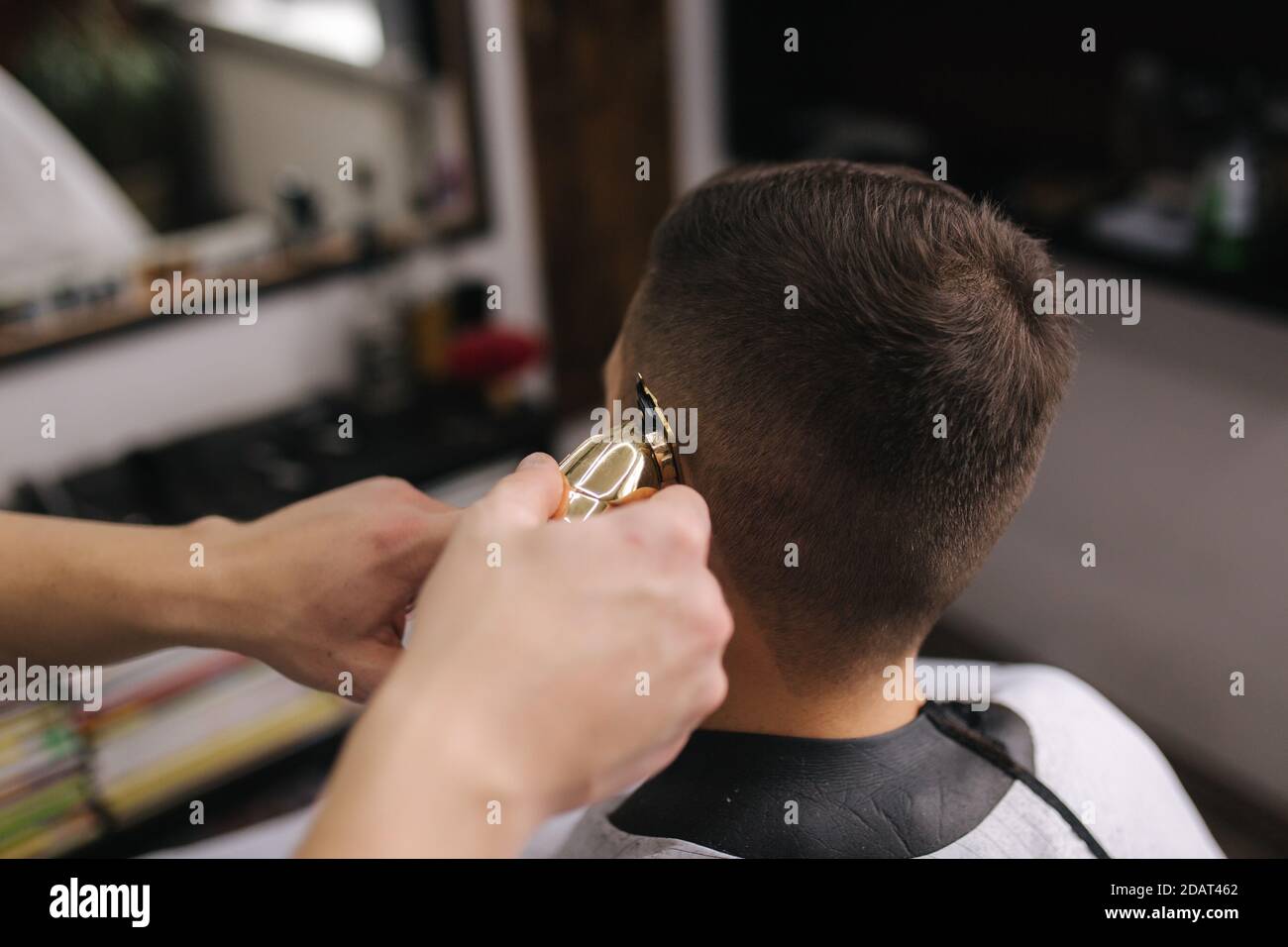 Professional hairdresser uses a hair clipper for fringing hair for a ...