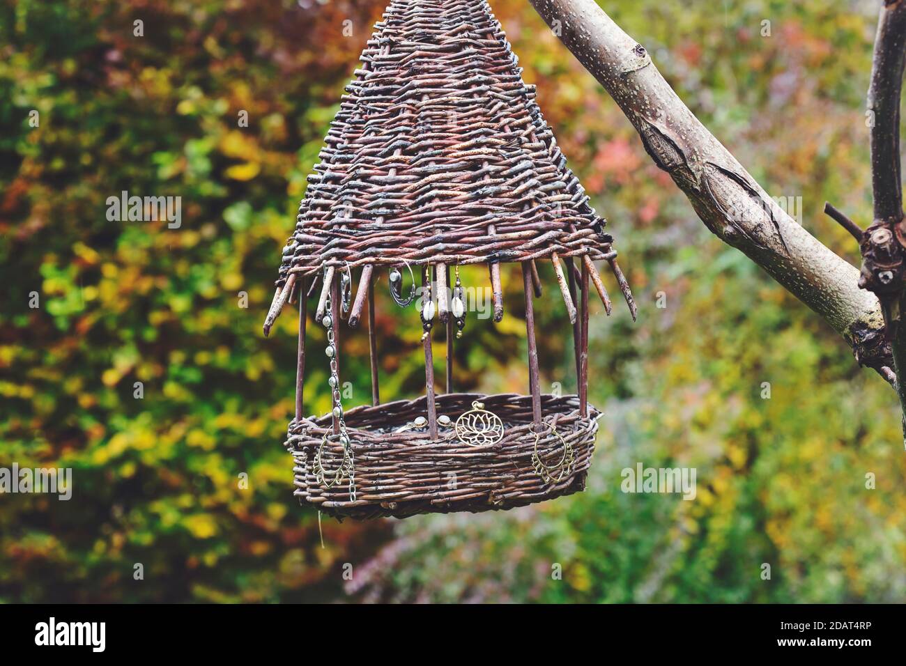 Outdoor closeup of handmade wicker bird feeder with sunflower seed and ...