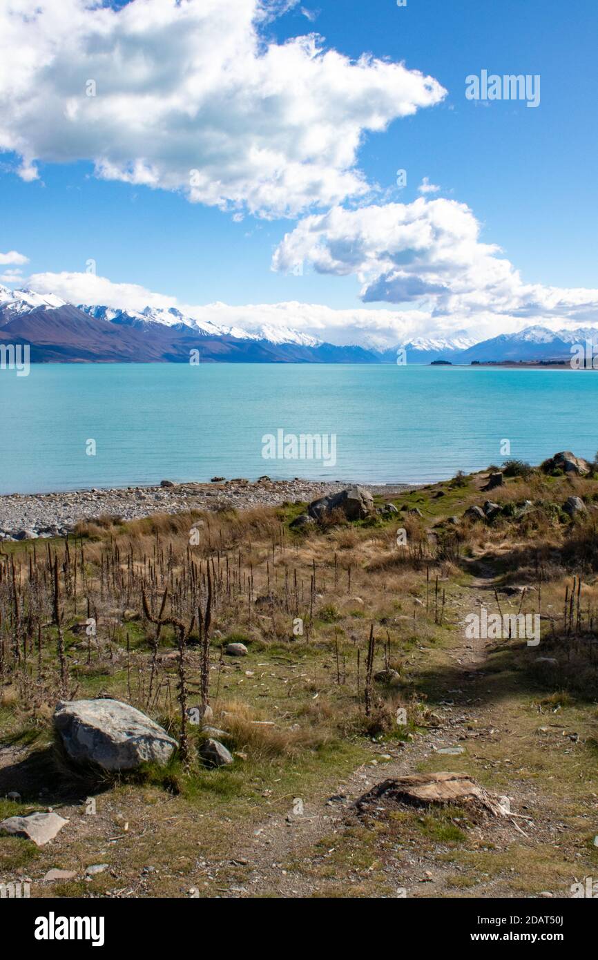 path leads down to blue lake edge Stock Photo - Alamy