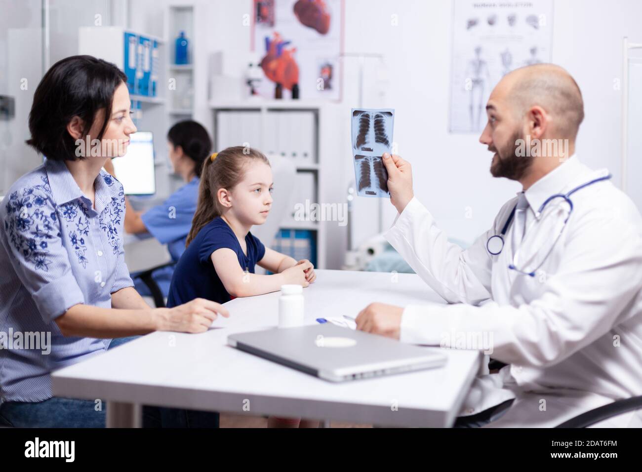 Pediatrician examining sick child radiography during medical ...