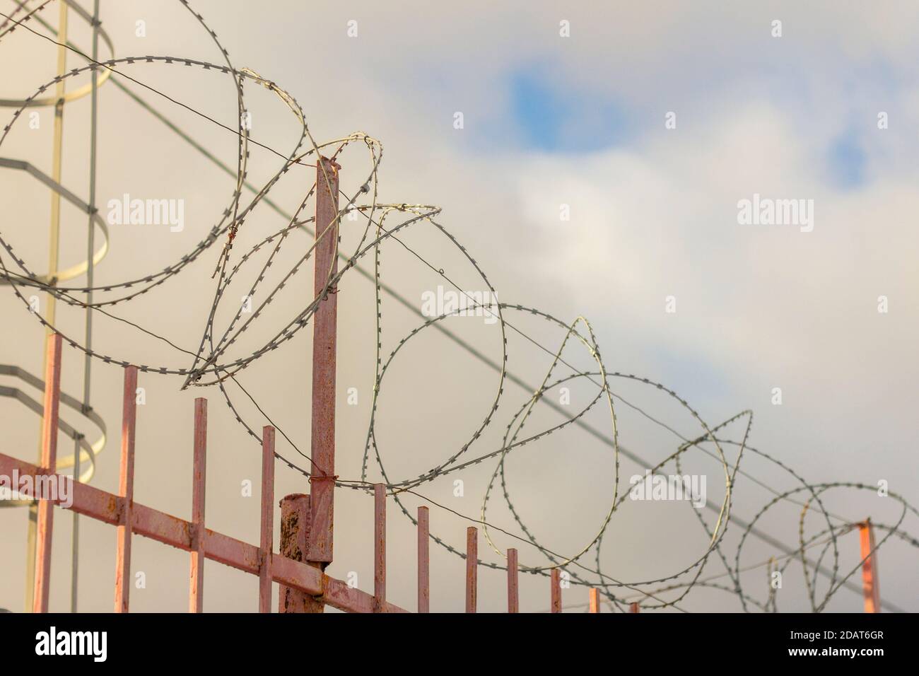 Barbed wire on a metal fence surrounding a dangerous object Stock Photo ...