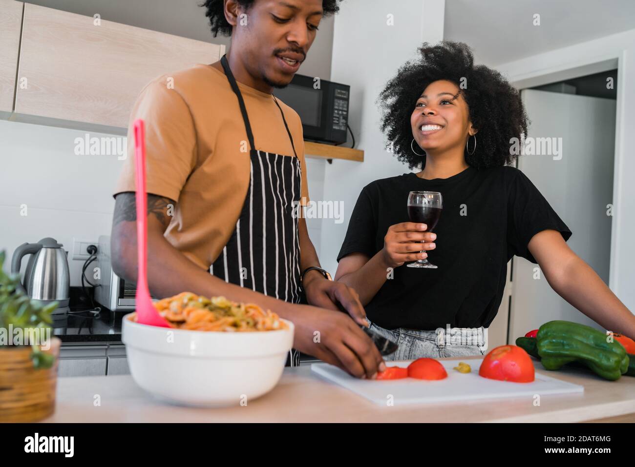 Afro couple cooking together in the kitchen Stock Photo - Alamy