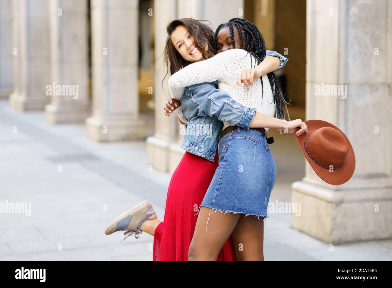 Two friends happy to see each other on the street hugging Stock Photo ...