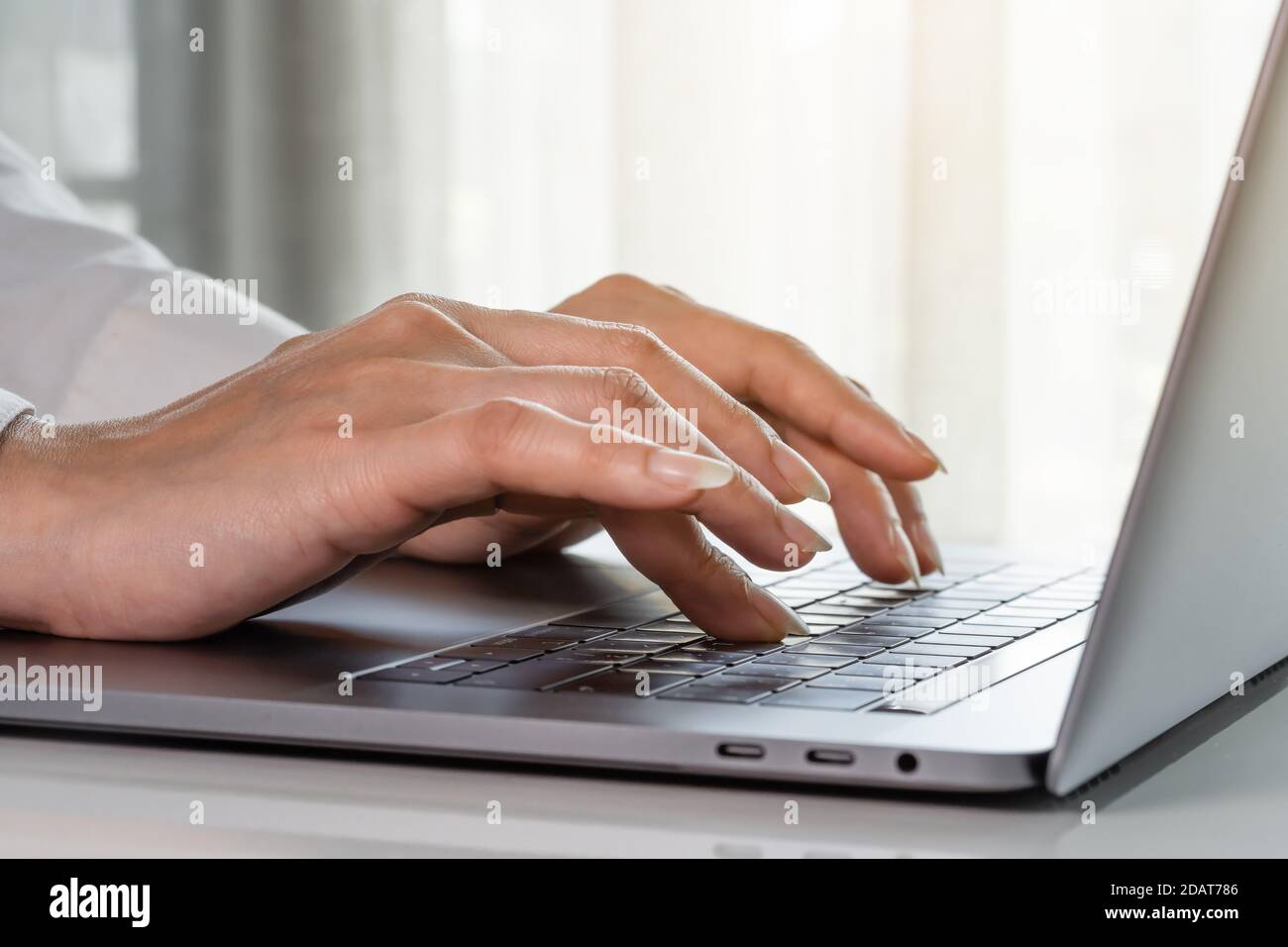 close-up female hands of business woman typing on a keyboard of laptop ...